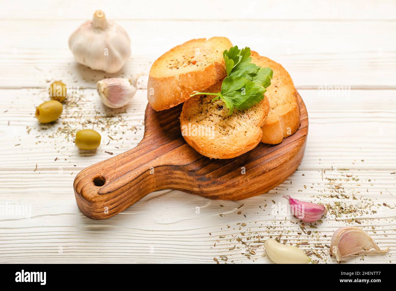 Board of tasty croutons on white wooden background Stock Photo - Alamy