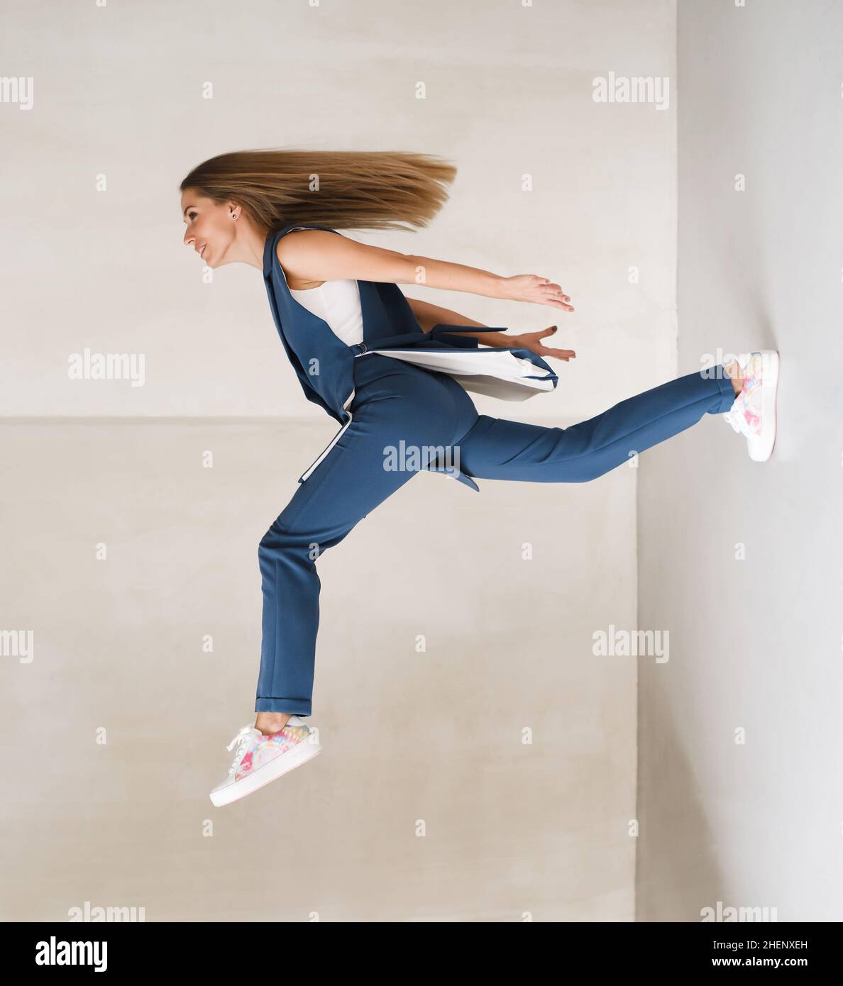 Creative balancing young woman ready to step or fall. Happy in business ...