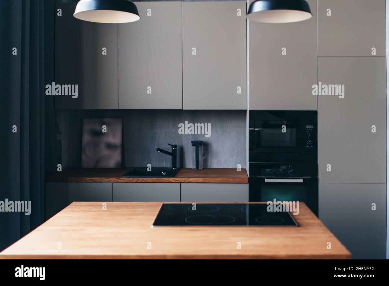 Modern kitchen with table and built-in hob. Interior design Stock Photo ...