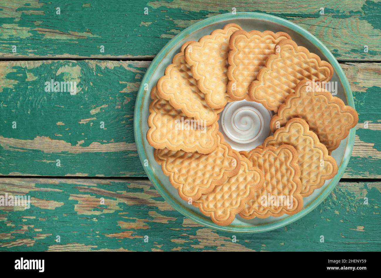 Vanilla square cookies in plate on old green wooden background, top ...