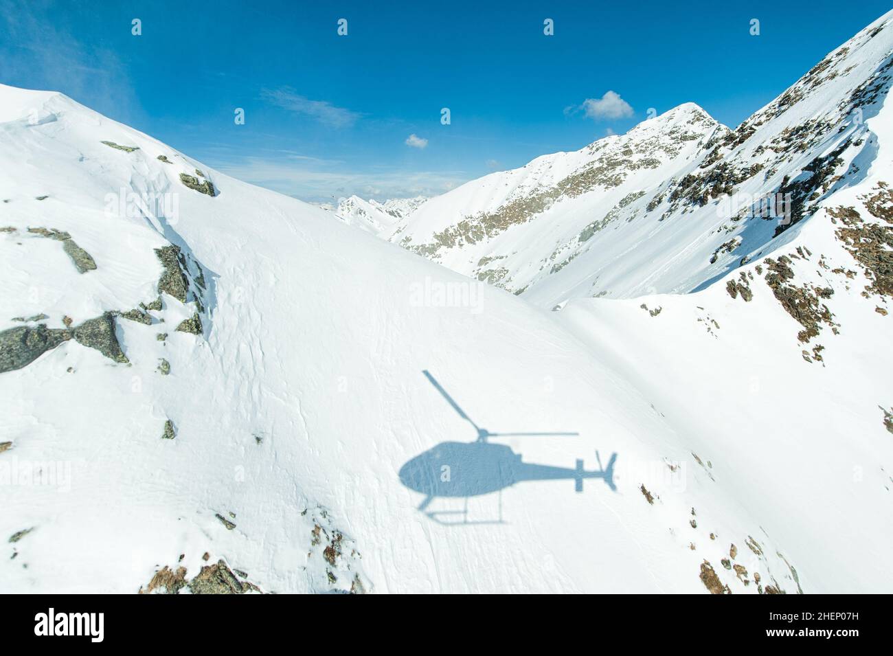 Helicopter shadow projected onto snow on mountain ridges Stock Photo ...
