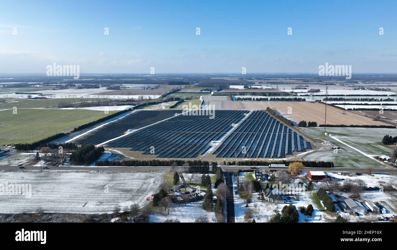 A large solar farm is seen on the horizon of a rural landscape on a ...