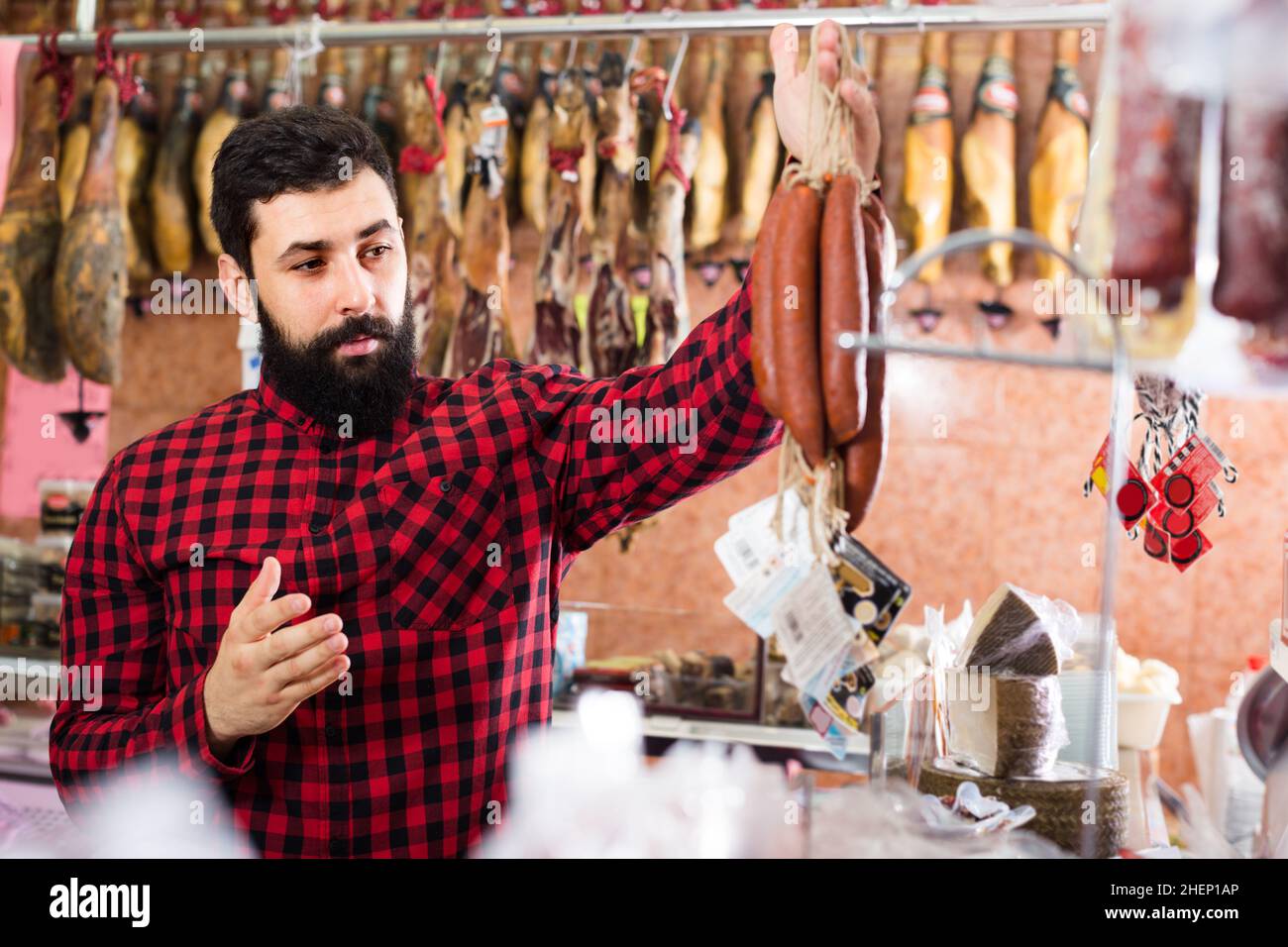 guy deciding on best sausage Stock Photo - Alamy