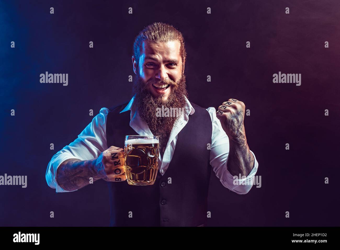 Happy bearded man holds mug of draft beer in hand while gesturing ...