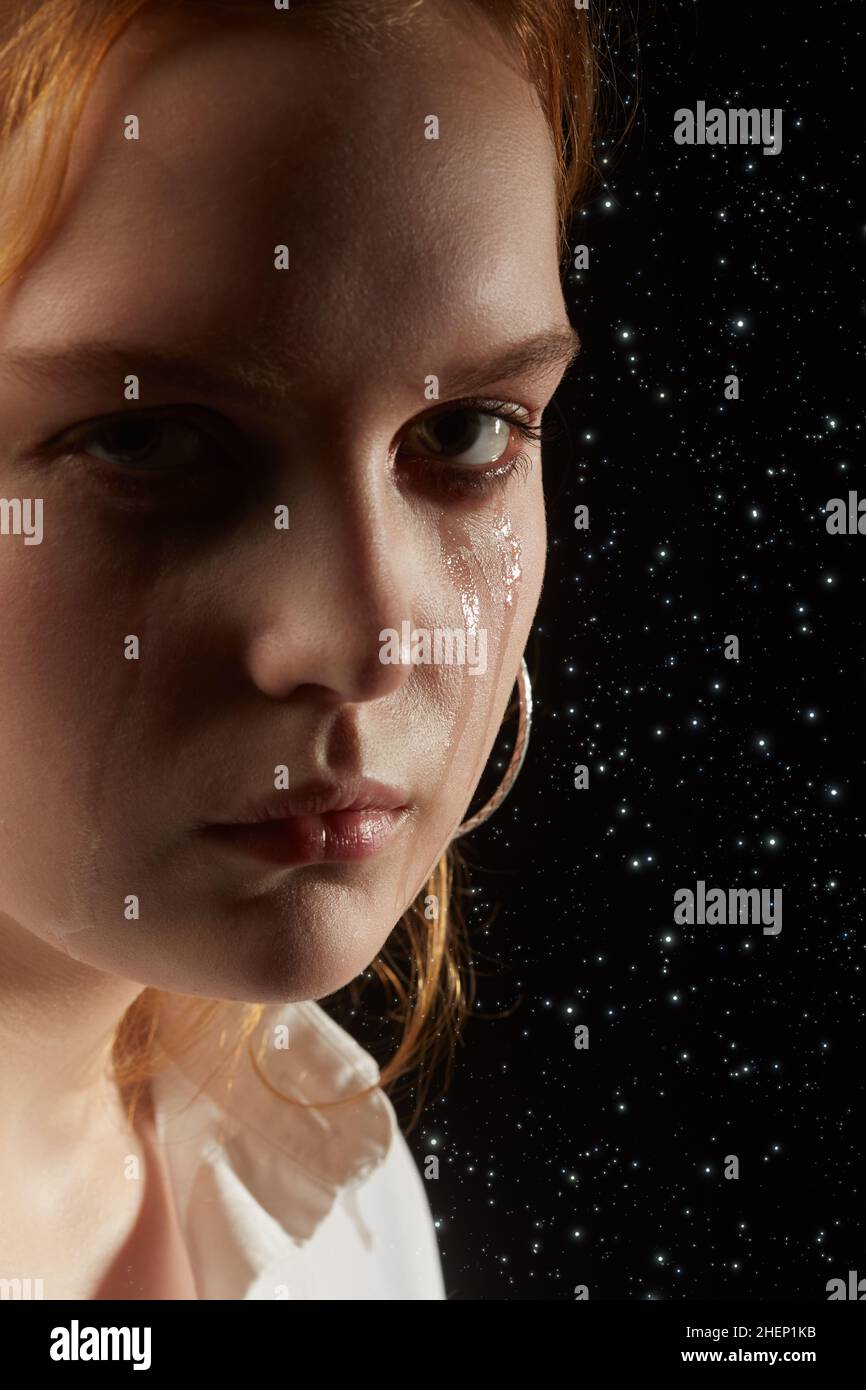 sad woman crying, looking at camera on stars background, closeup ...