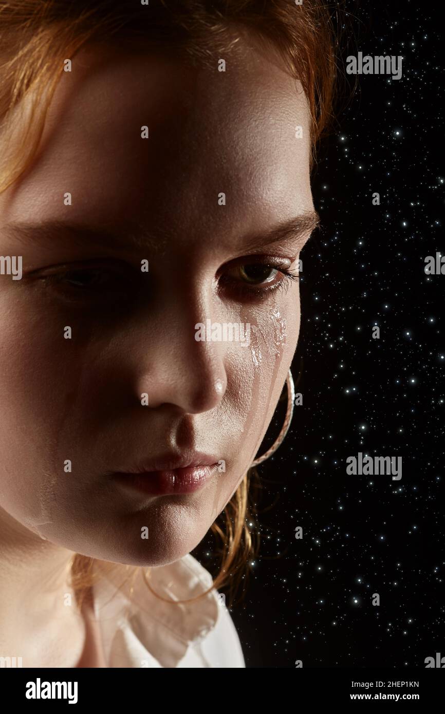 sad woman crying, looking aside on stars background, closeup portrait ...