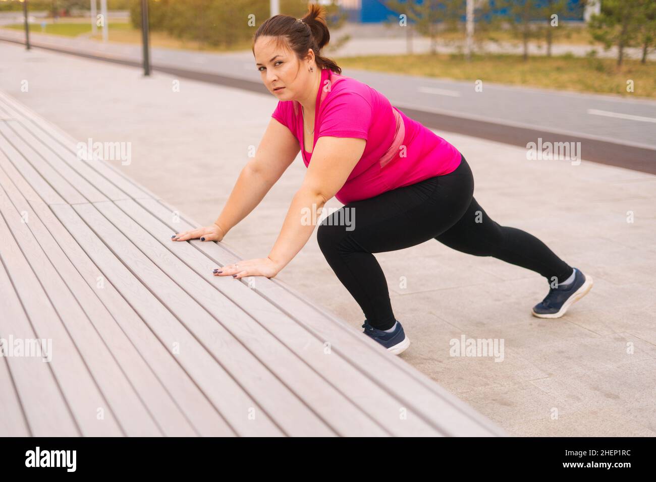 Side view of motivated fat young woman training doing push ups using ...