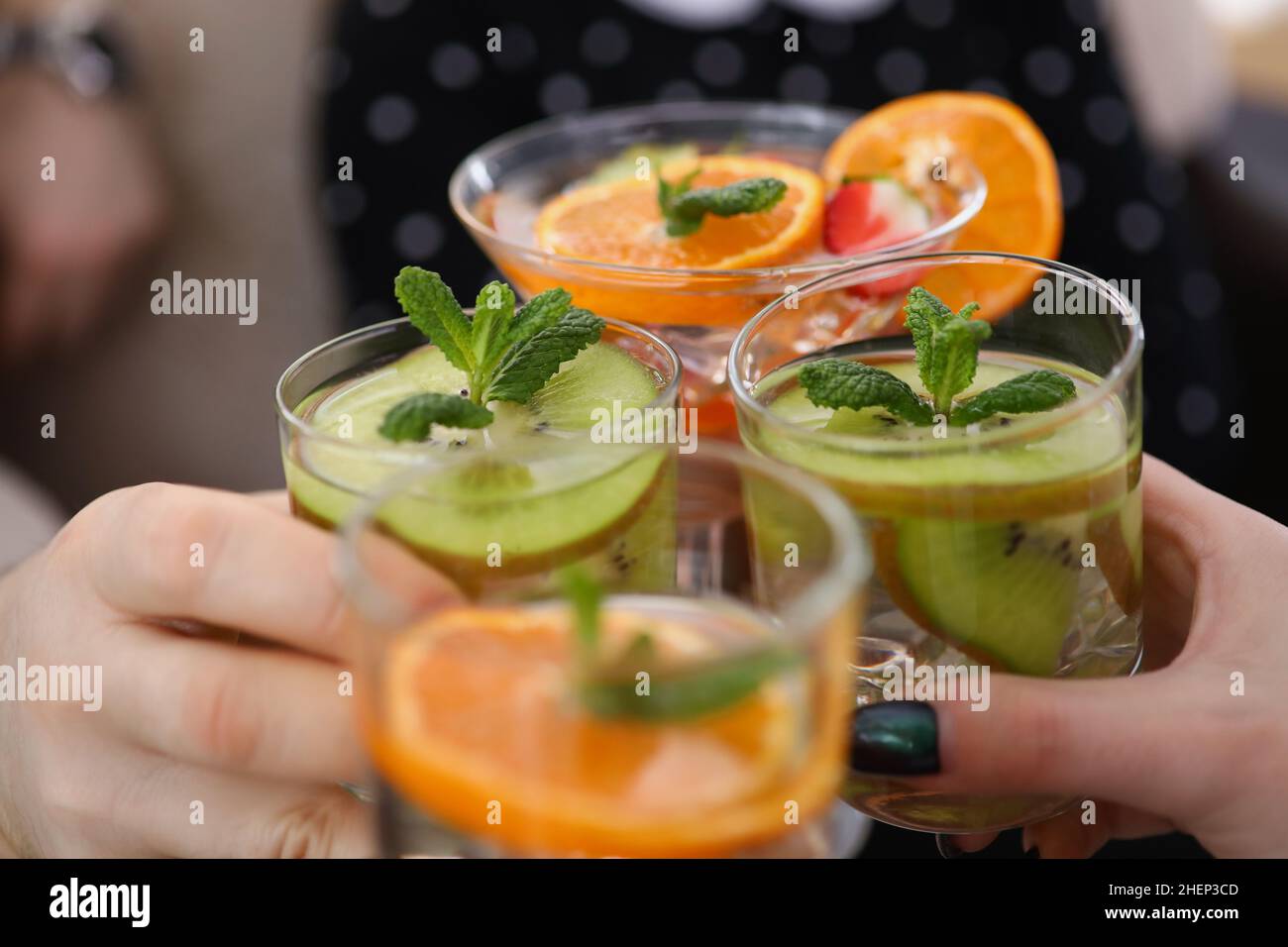 Group of people with cooling drinks make clink with glasses, raise ...