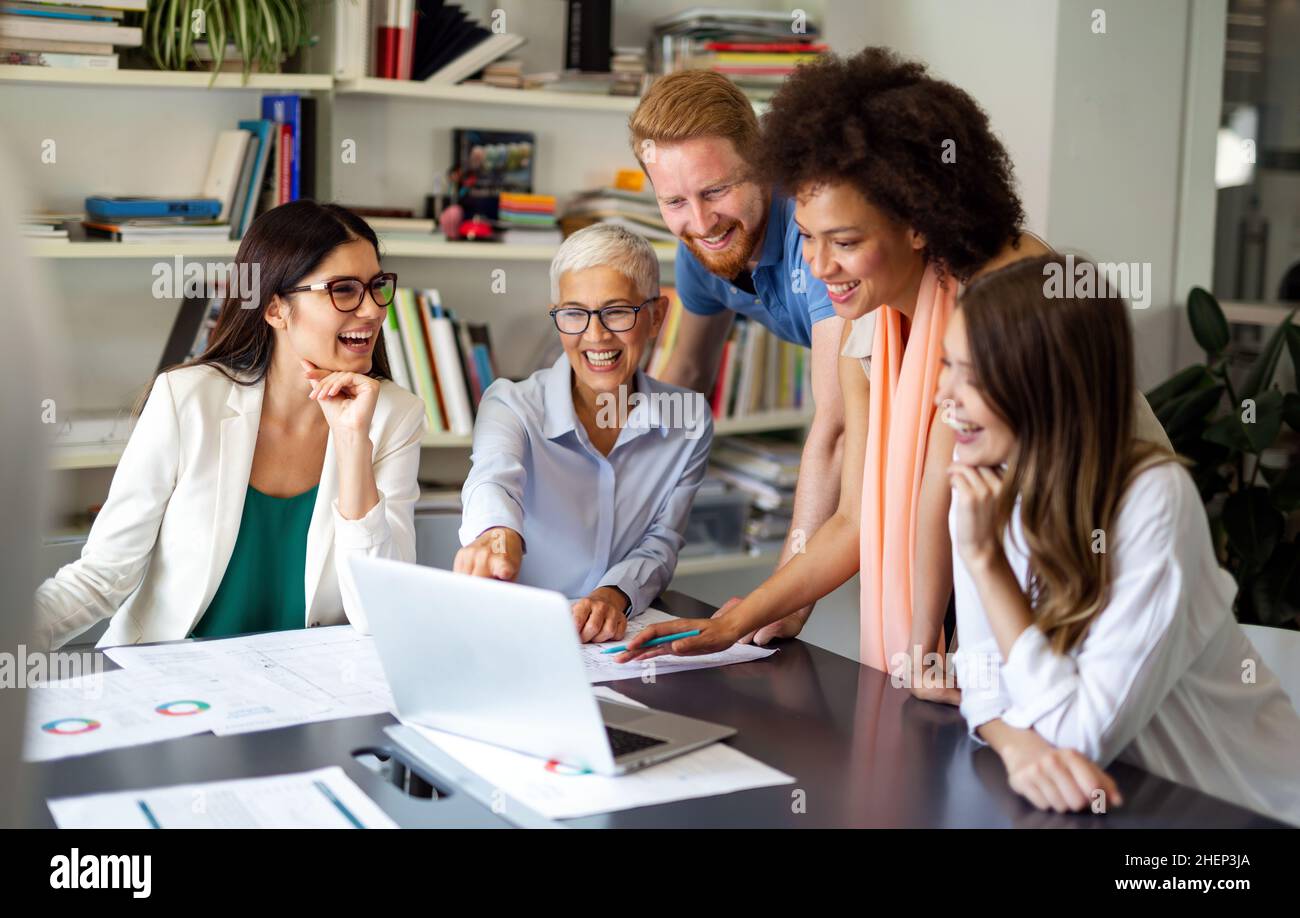 Group of happy business people discussing and working together during a ...