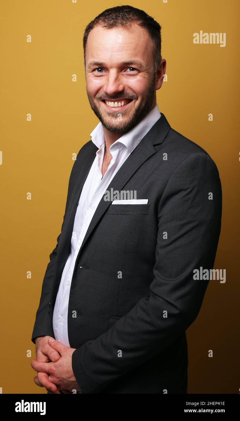 Portrait of a beautiful happy man in front of a colored background ...
