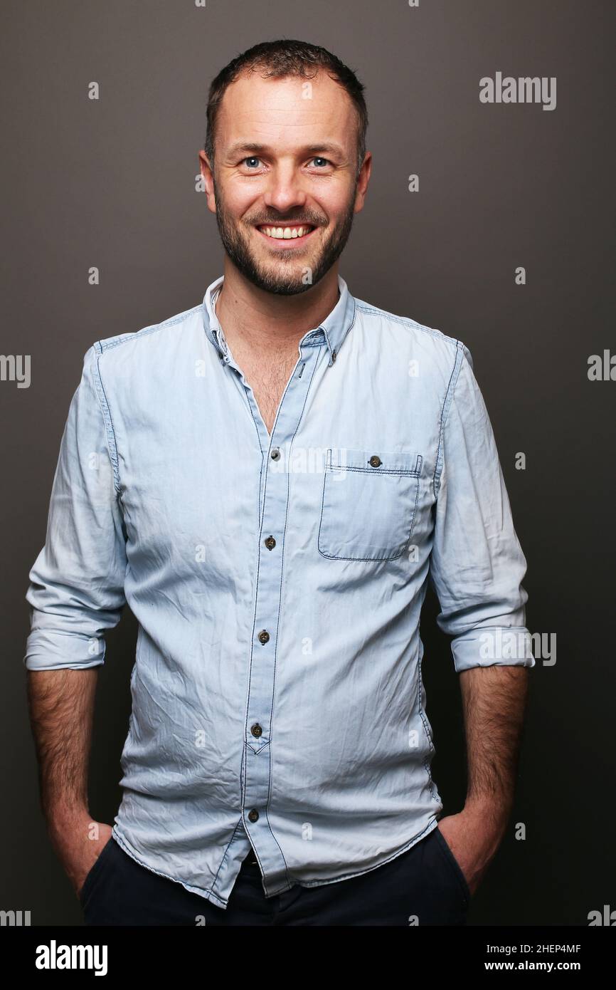 Portrait of a beautiful happy man in front of a colored background ...