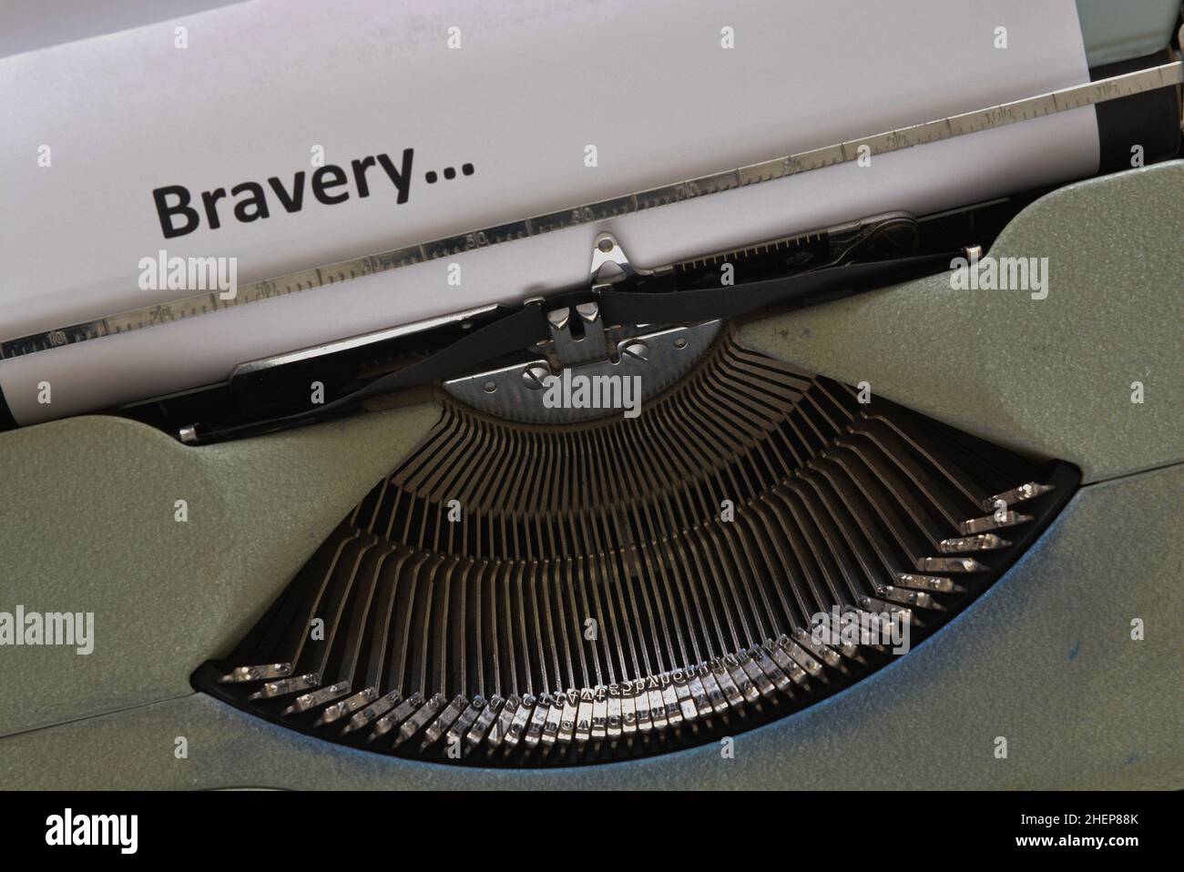 Bravery - word typed bold on white paper held on typewriter platen ...