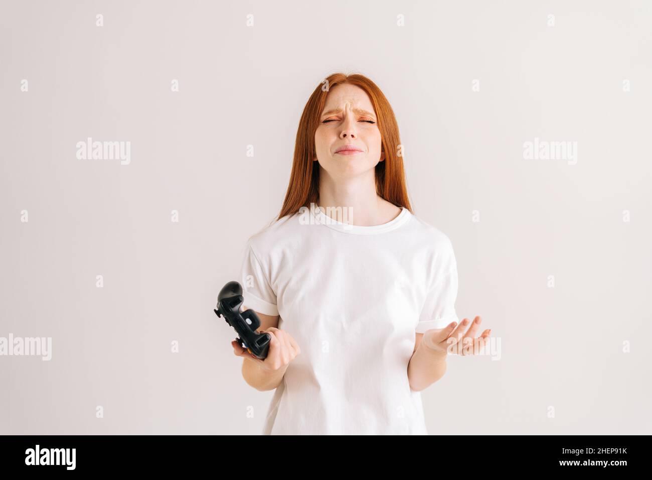 Studio portrait of unhappy crying young woman losing at video games on ...