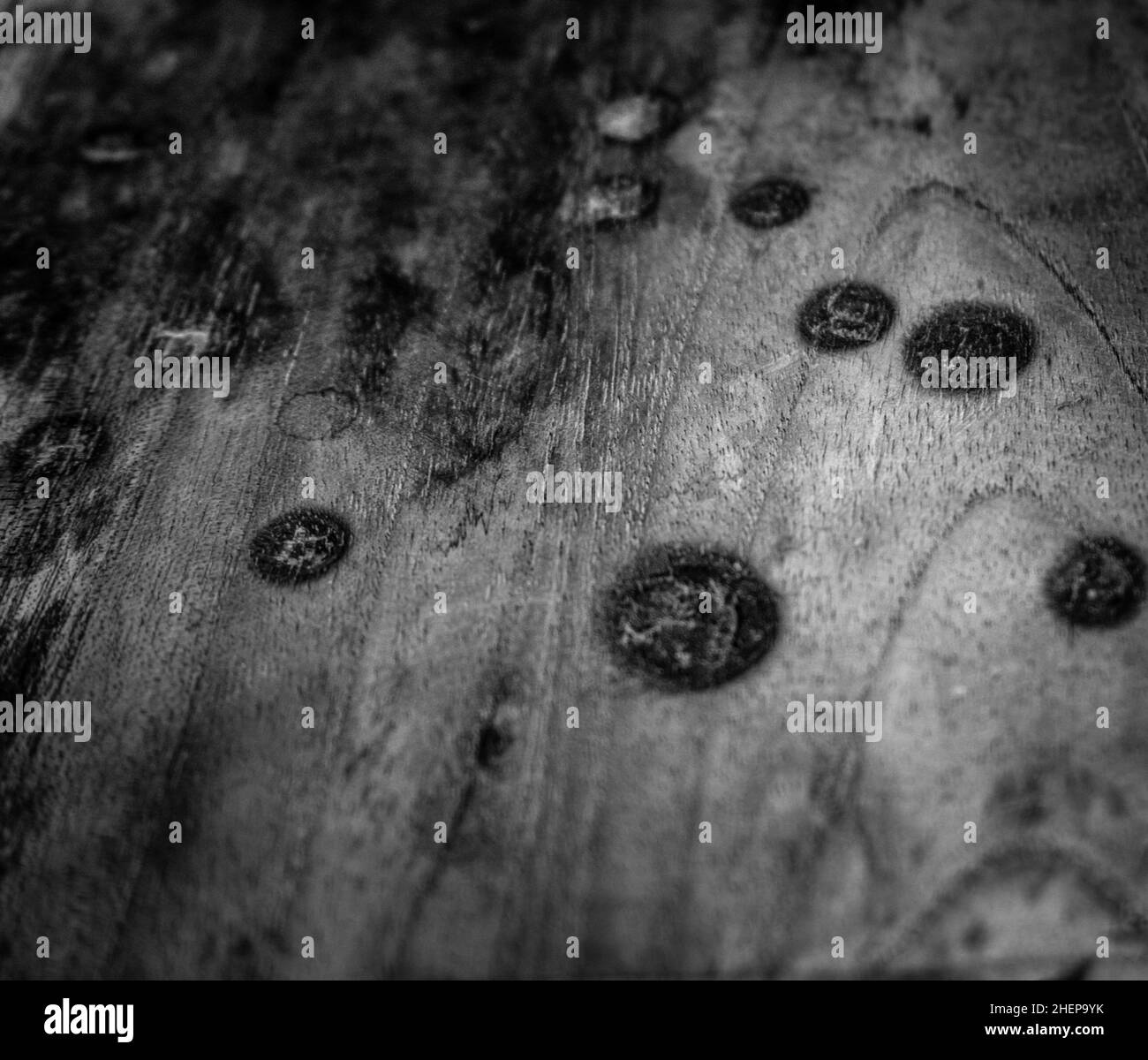 A close-up shot of textured tabletop made of wood with a black burnt ...