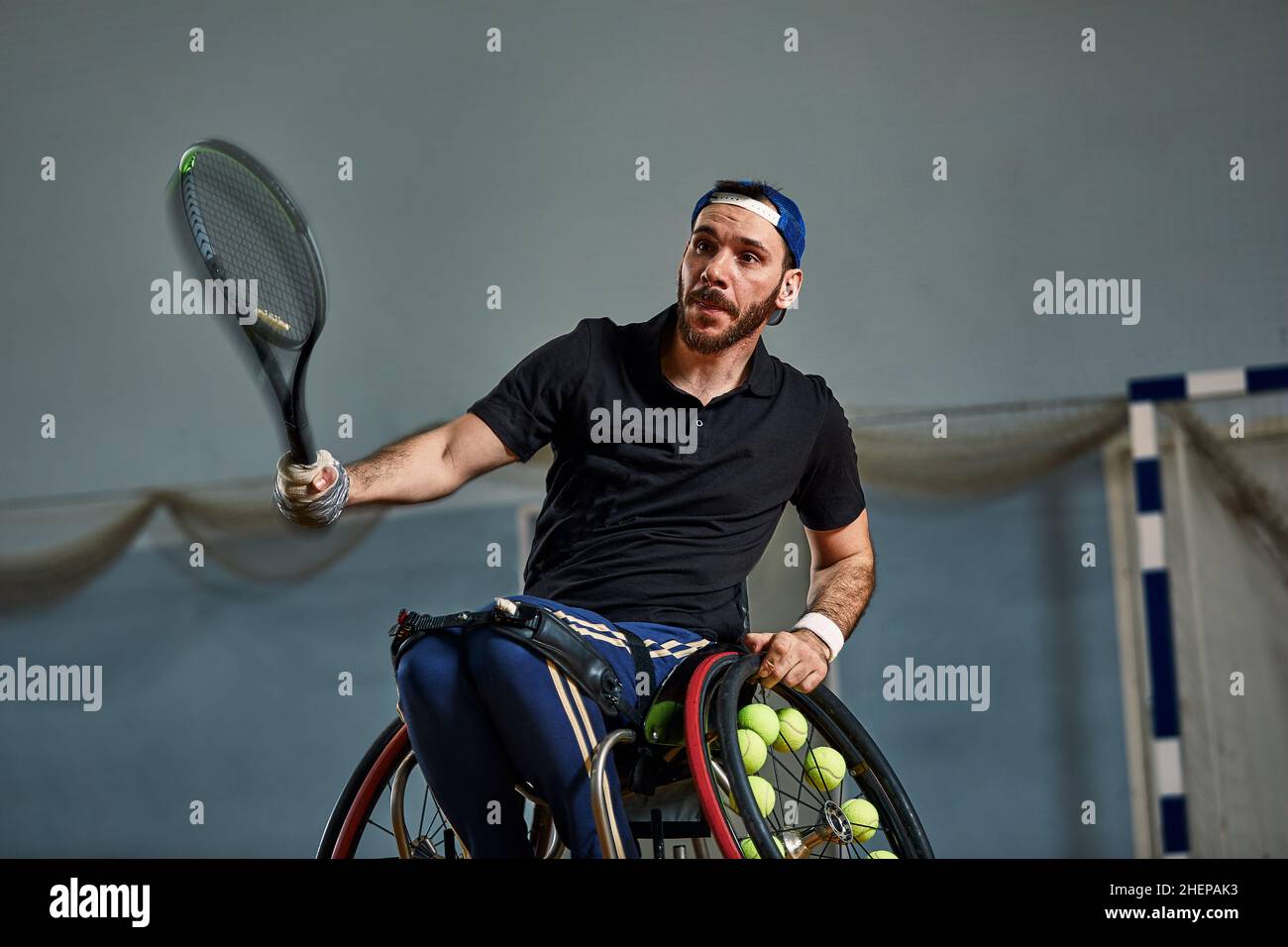 young man with a physical disability playing tennis on wheelchair on ...