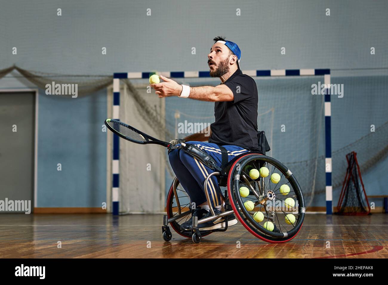 young man with a physical disability playing tennis on wheelchair on ...