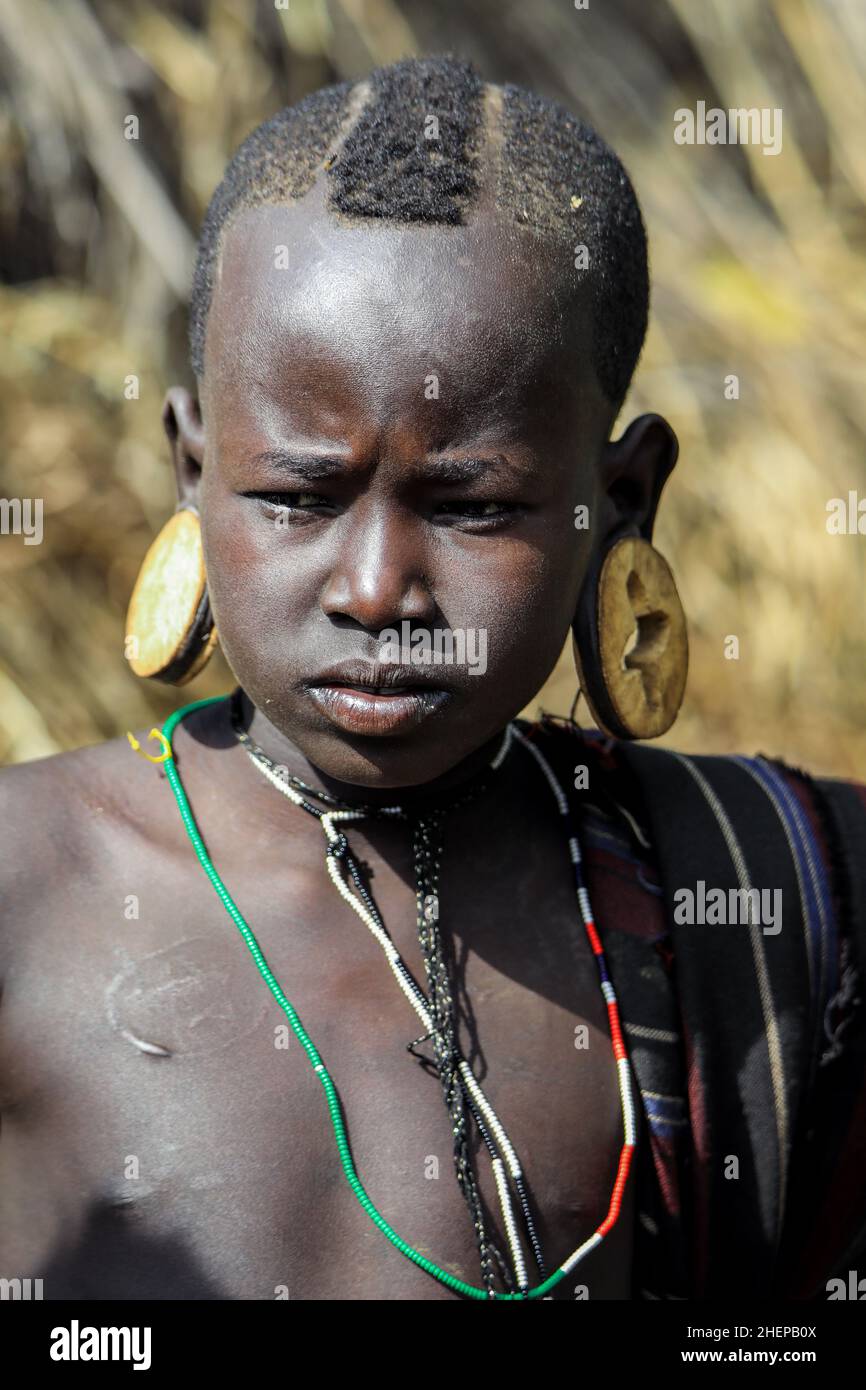 Mursi People Children in National Costumes in the Tribe Village Stock ...