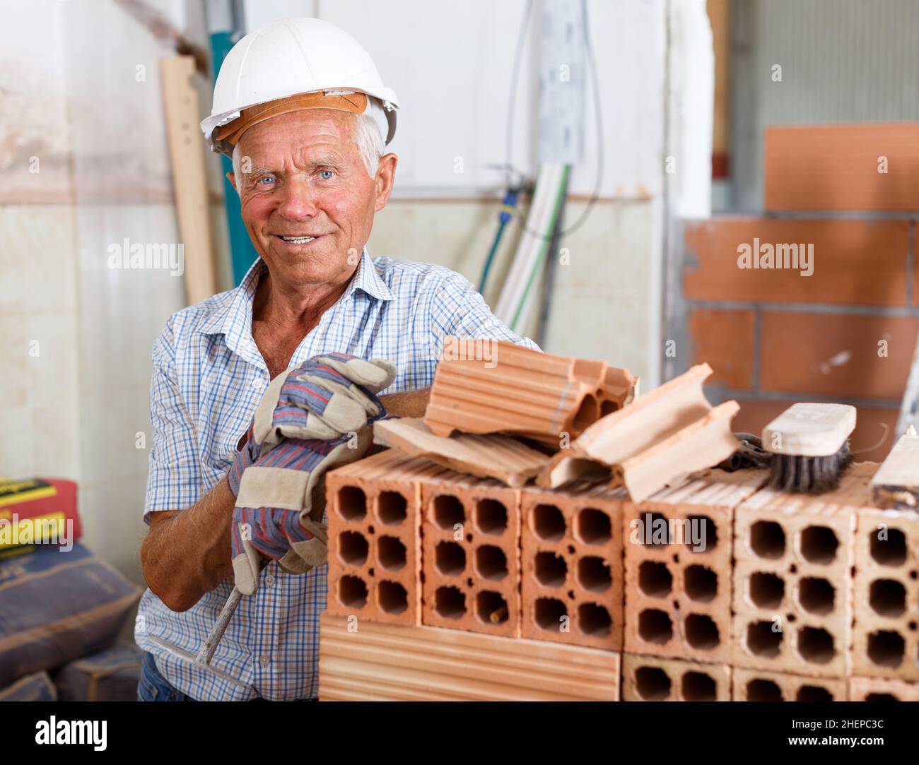 Happy bricklayer near brick stack Stock Photo - Alamy