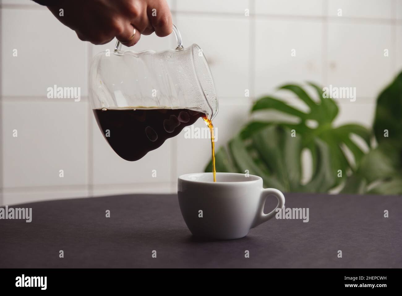 man's hand pouring coffee from glass coffee pot into a white cup Stock ...