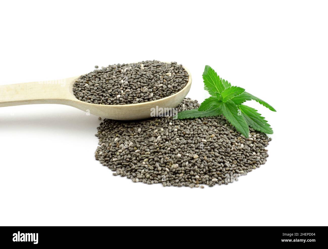 Chia seeds in wooden spoon and green chia leaves on white background ...
