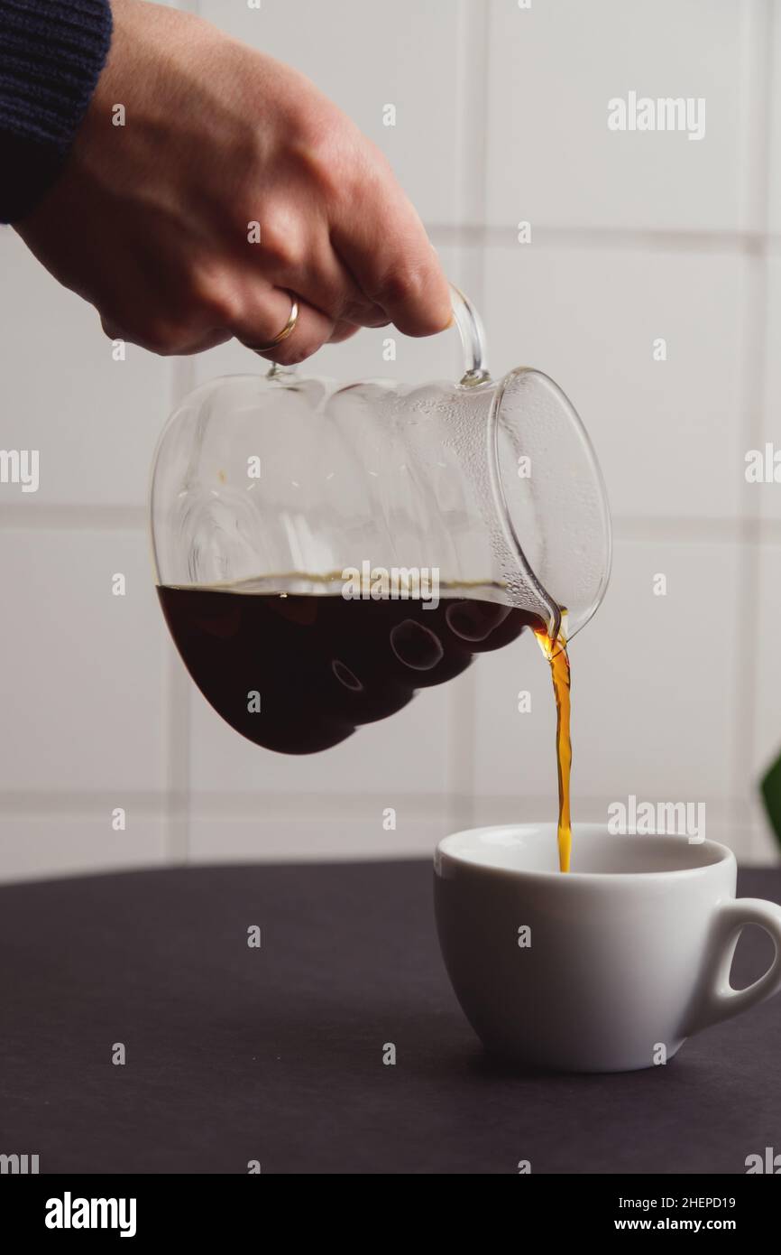 man's hand pouring coffee from glass coffee pot into a white cup Stock ...
