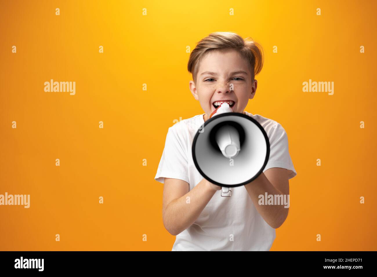 Little boy with megaphone on yellow background Stock Photo - Alamy