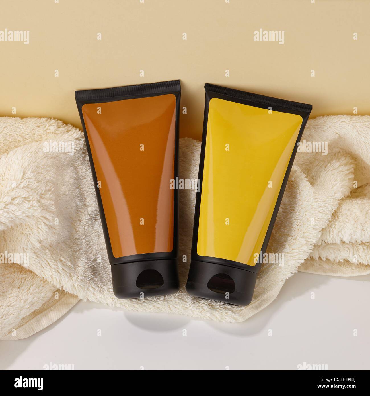 Color plastic tubes with body care product on towels Stock Photo - Alamy