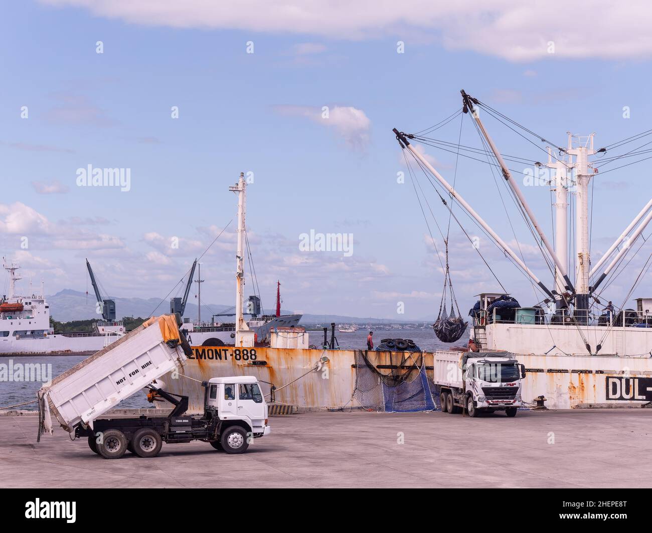 Tuna shuttle vessel unloading yellowfin tuna onto waiting lorries at ...