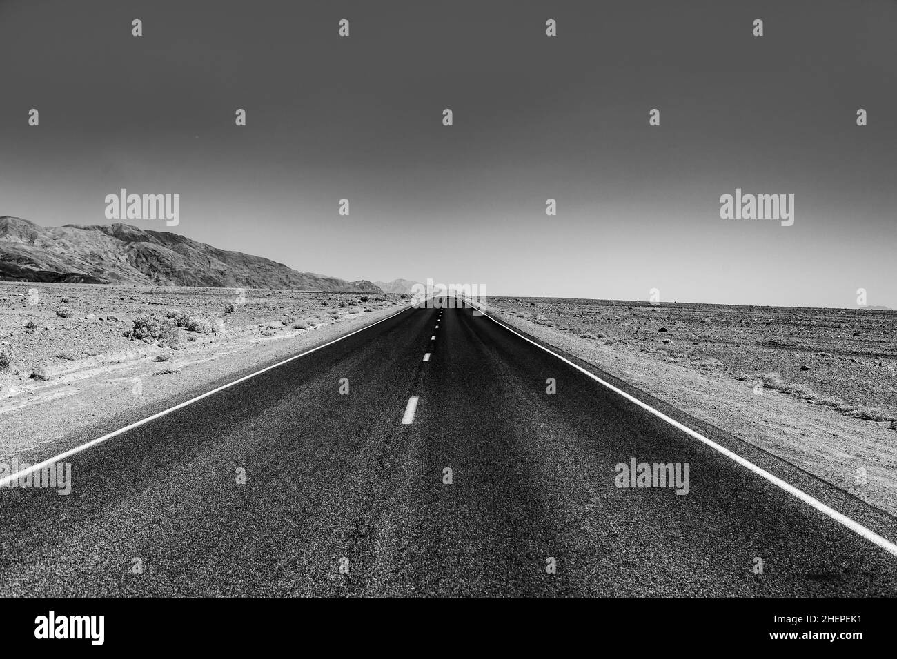 empty road through the death valley desert under blue sky Stock Photo ...