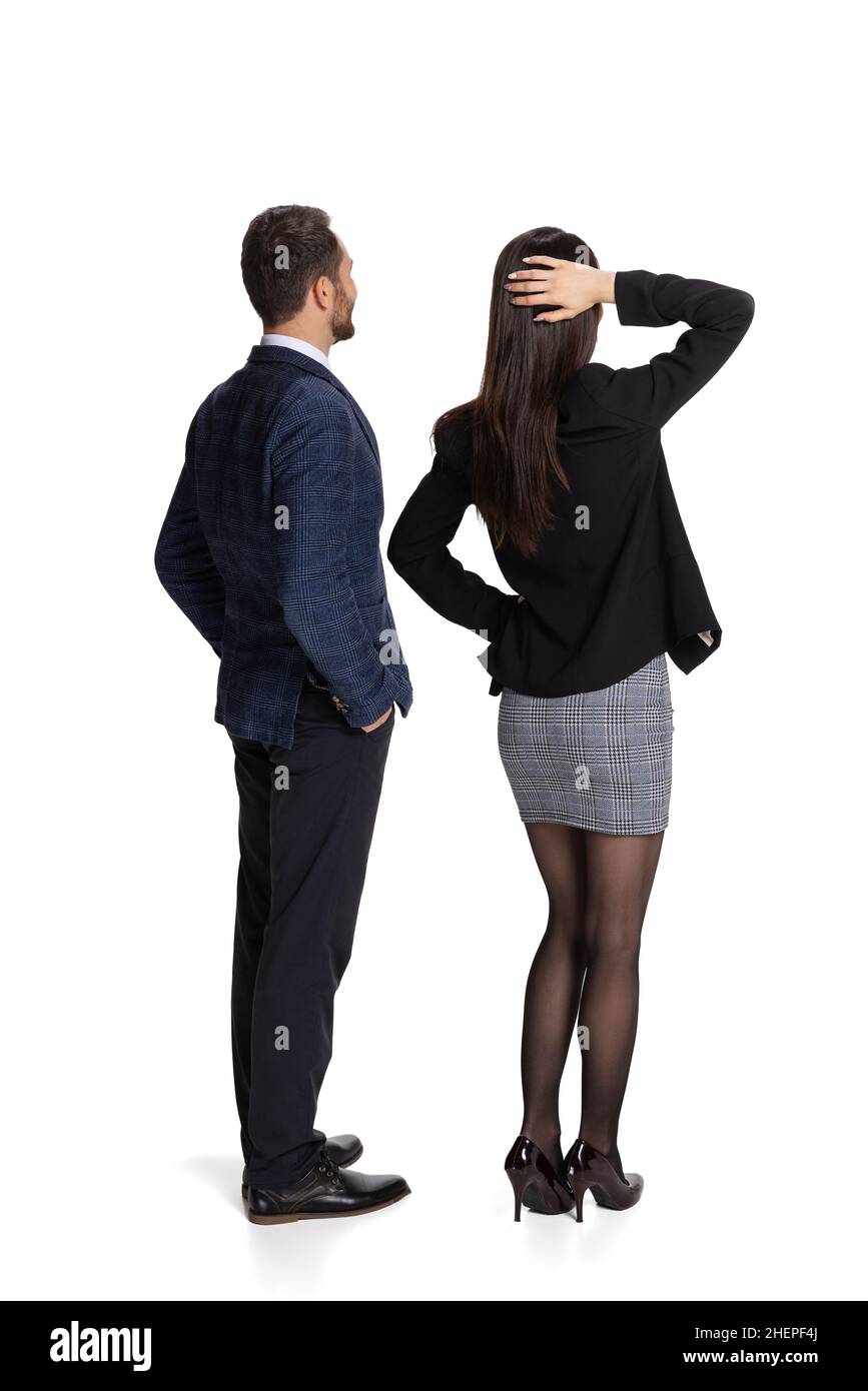 Full-length back view portrait of two office workers looking on board ...