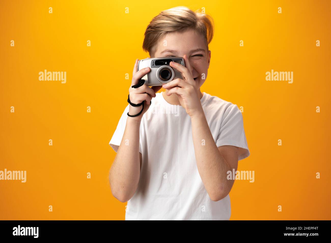 Little boy with an old camera on a yellow background Stock Photo - Alamy