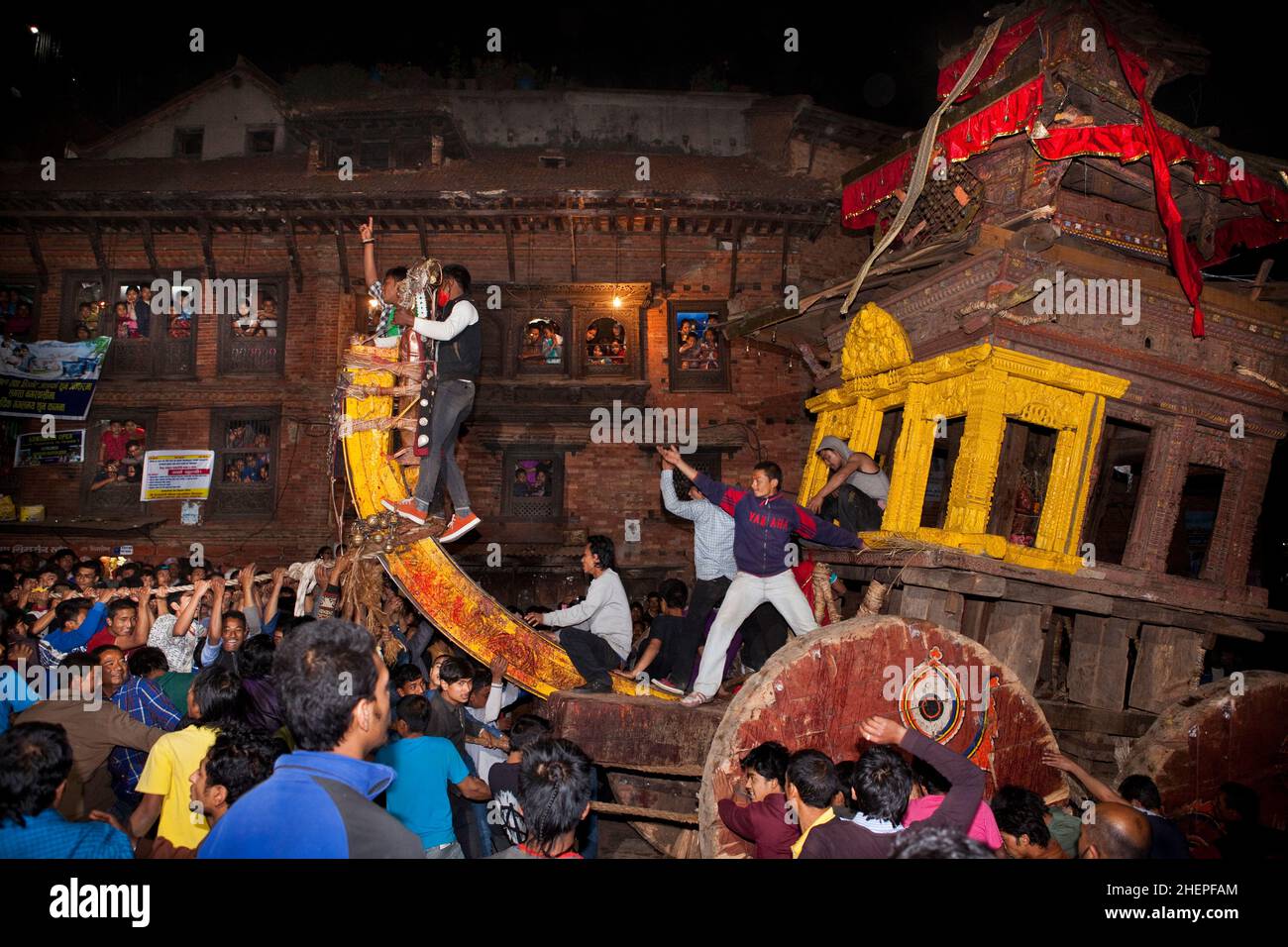 Residents hall a multi-tonne wooden chariot through the streets of ...
