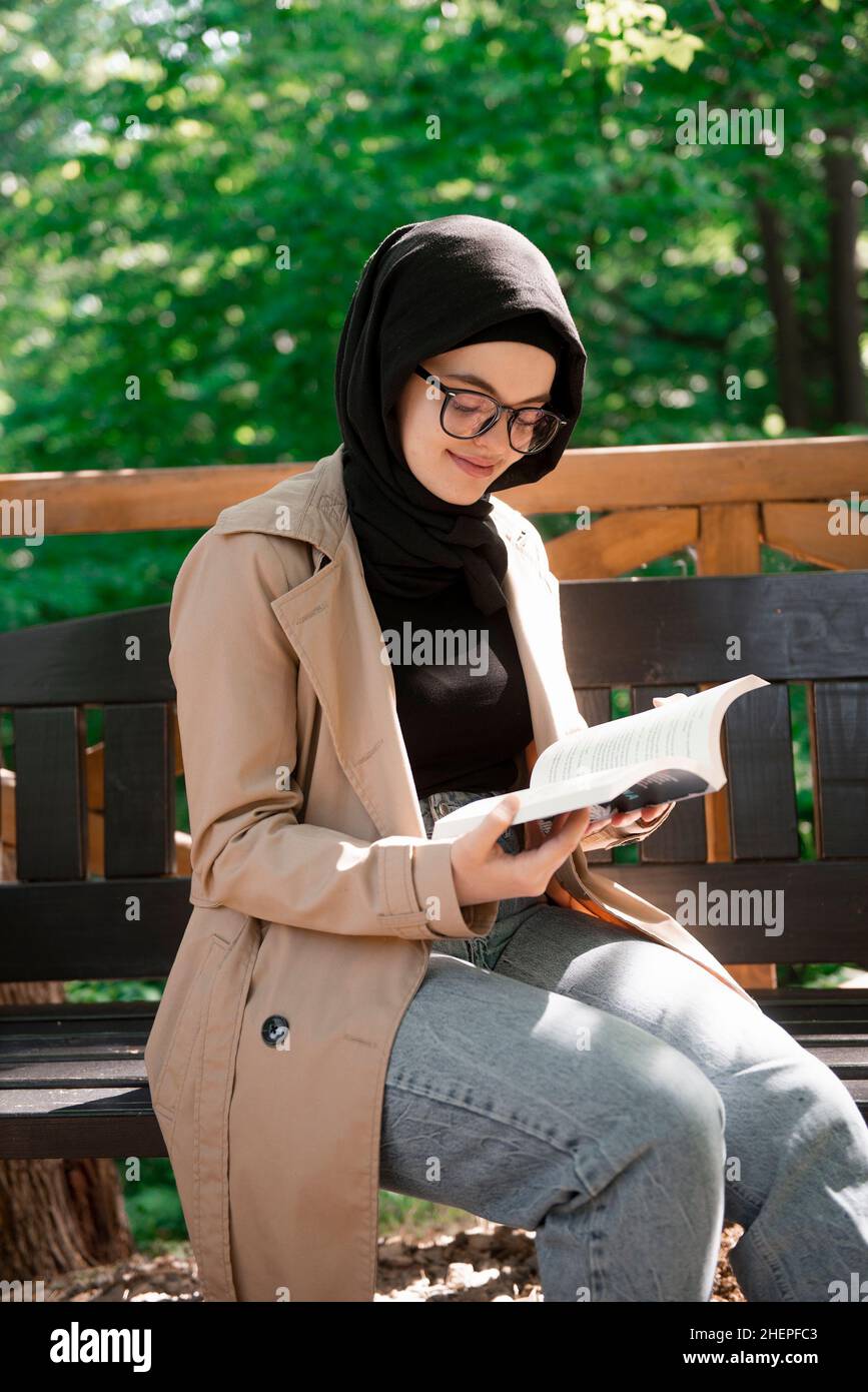 Young Muslim woman reading poetry in silence on a beautiful spring day ...