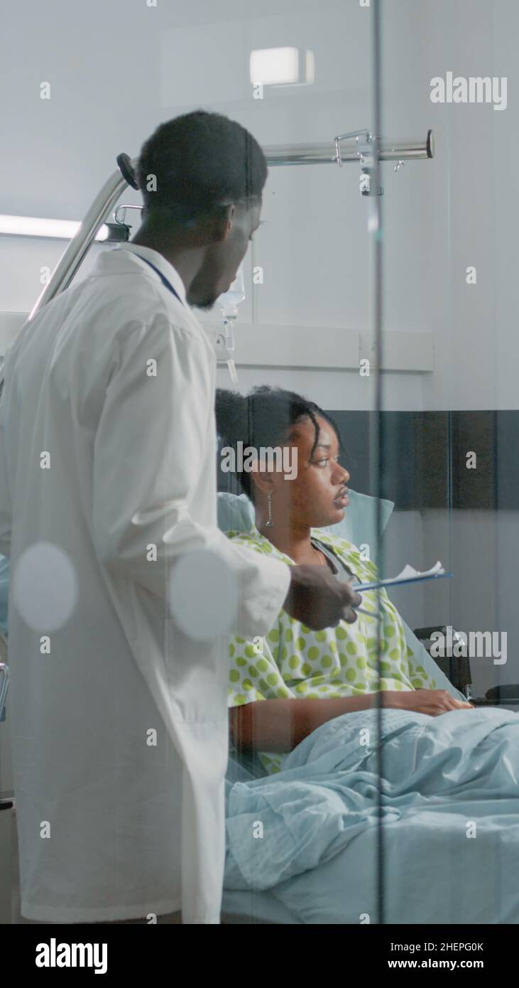 Sick patient receiving medical assistance from team of doctors in ...