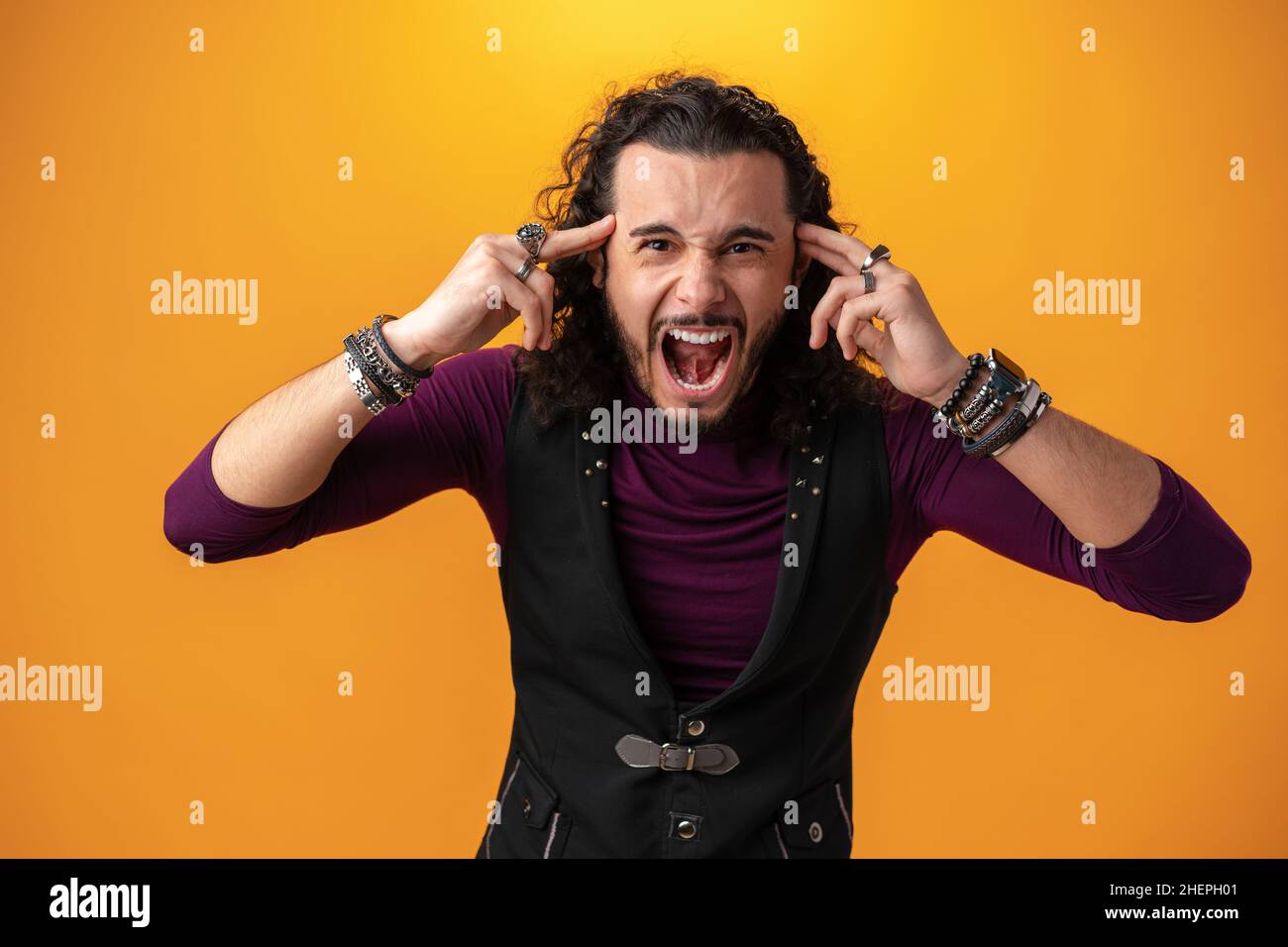 Angry young guy look in camera and scream against yellow background ...
