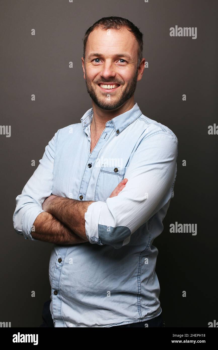 Portrait of a beautiful happy man in front of a colored background ...