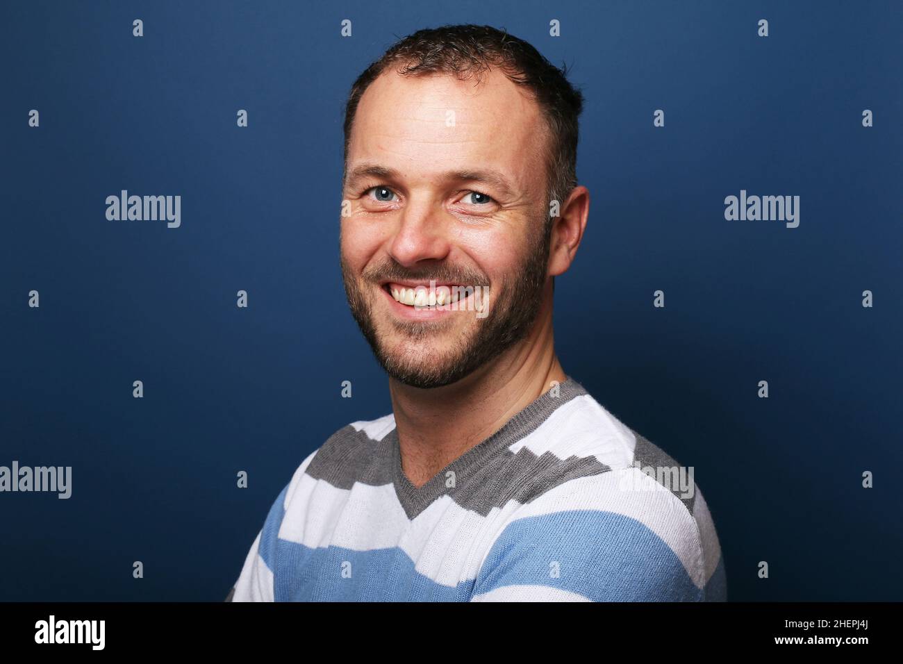 Portrait of a beautiful happy man in front of a colored background ...
