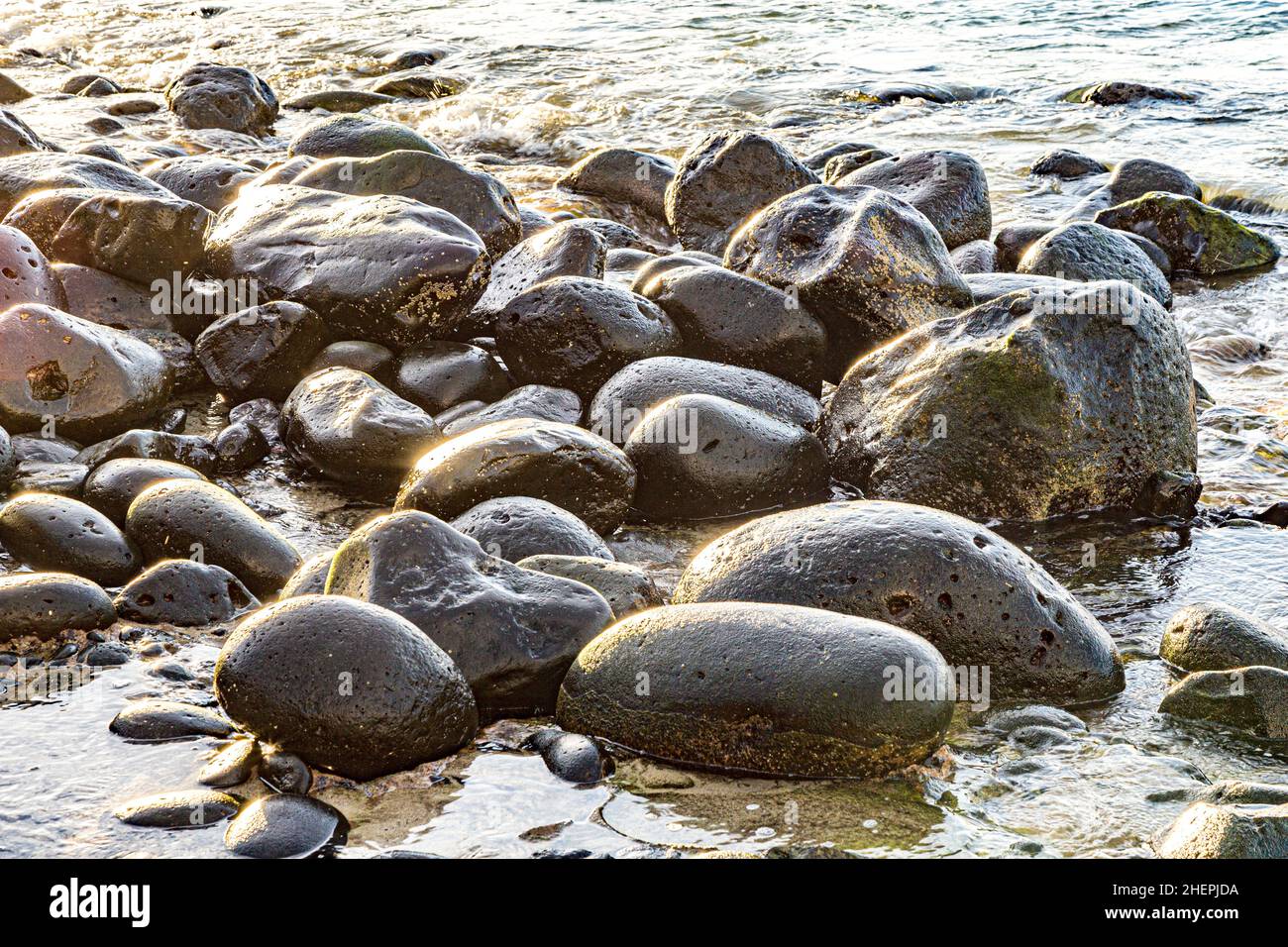 pebble stone beach in morning light with harmonic reflections Stock ...