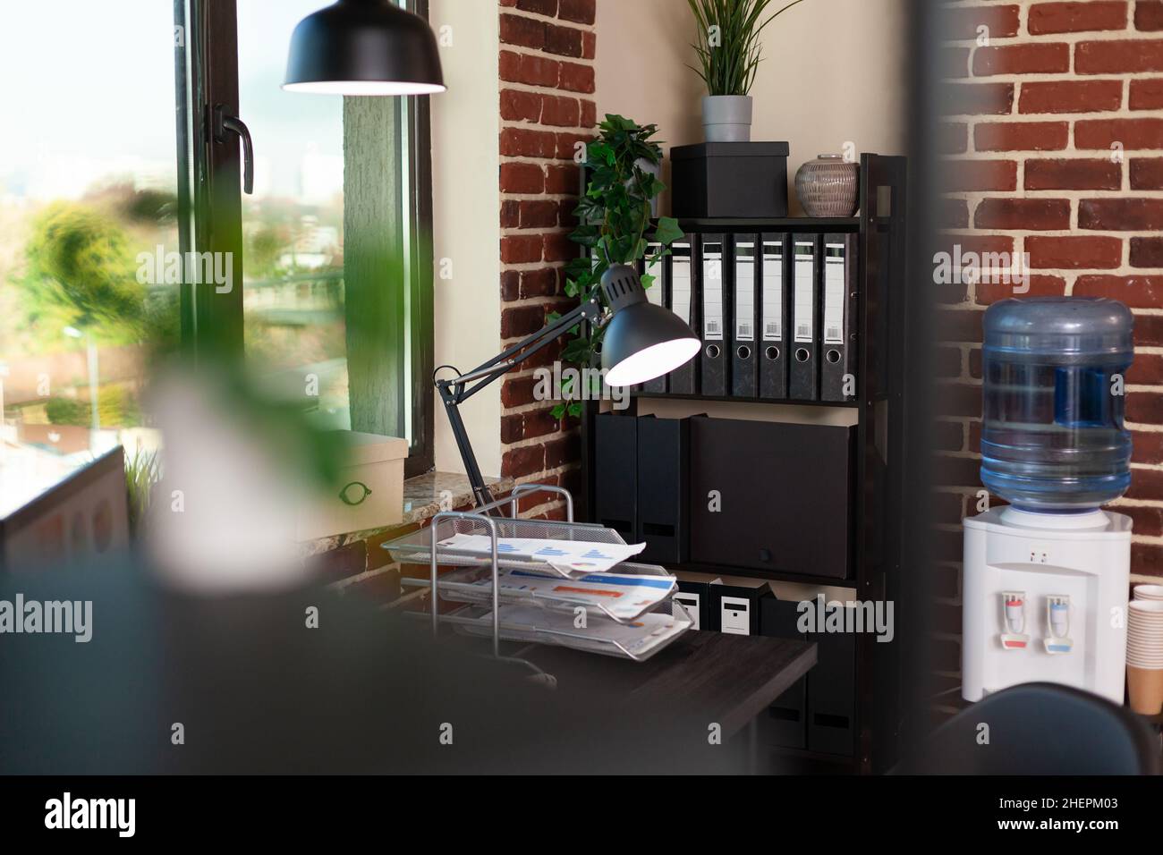 Close up of desk and bookshelf with decorations in office. Empty table ...