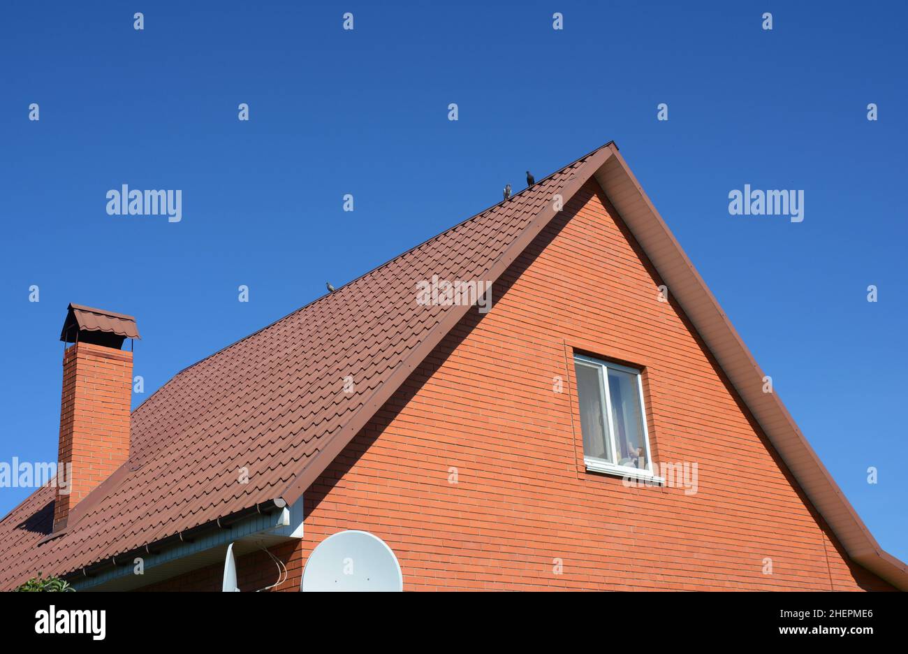 Red Metal Roofing New Brick House. Old faded red metal roof tile and ...