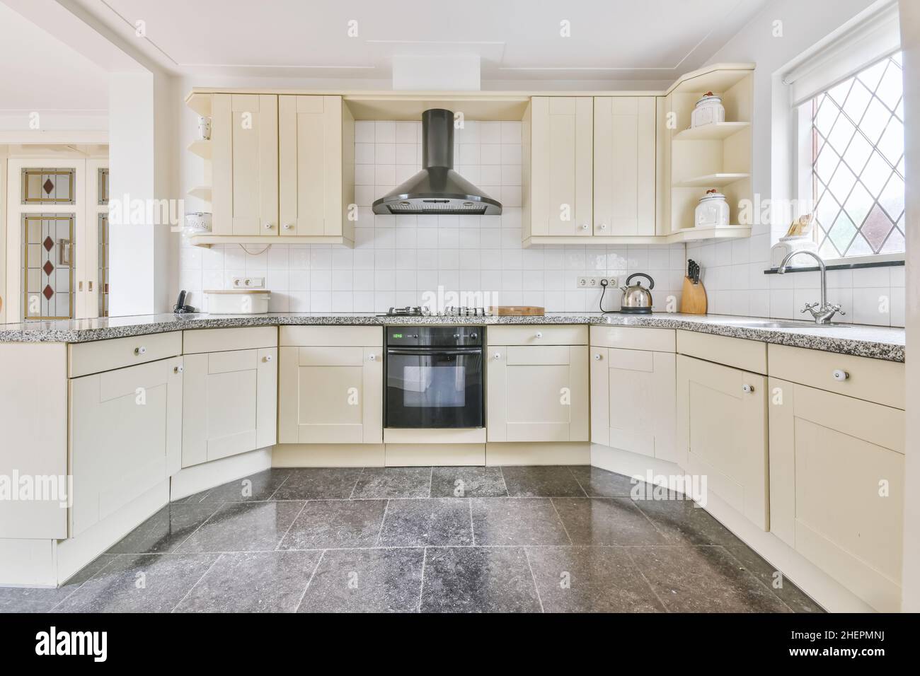 Large kitchen with beige kitchen unit and tiled floor Stock Photo - Alamy