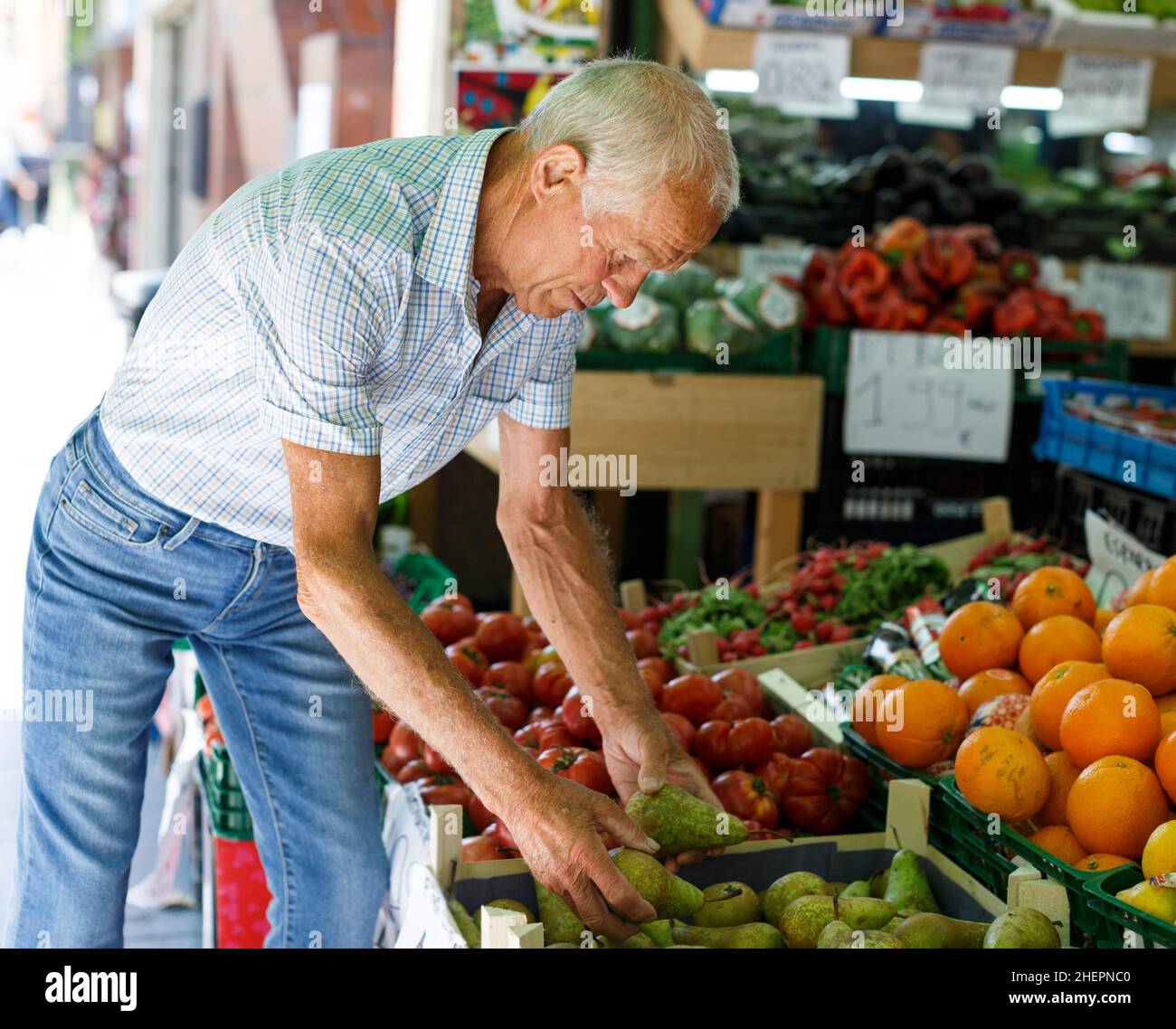 Man searching for fruits in greengrocery Stock Photo - Alamy