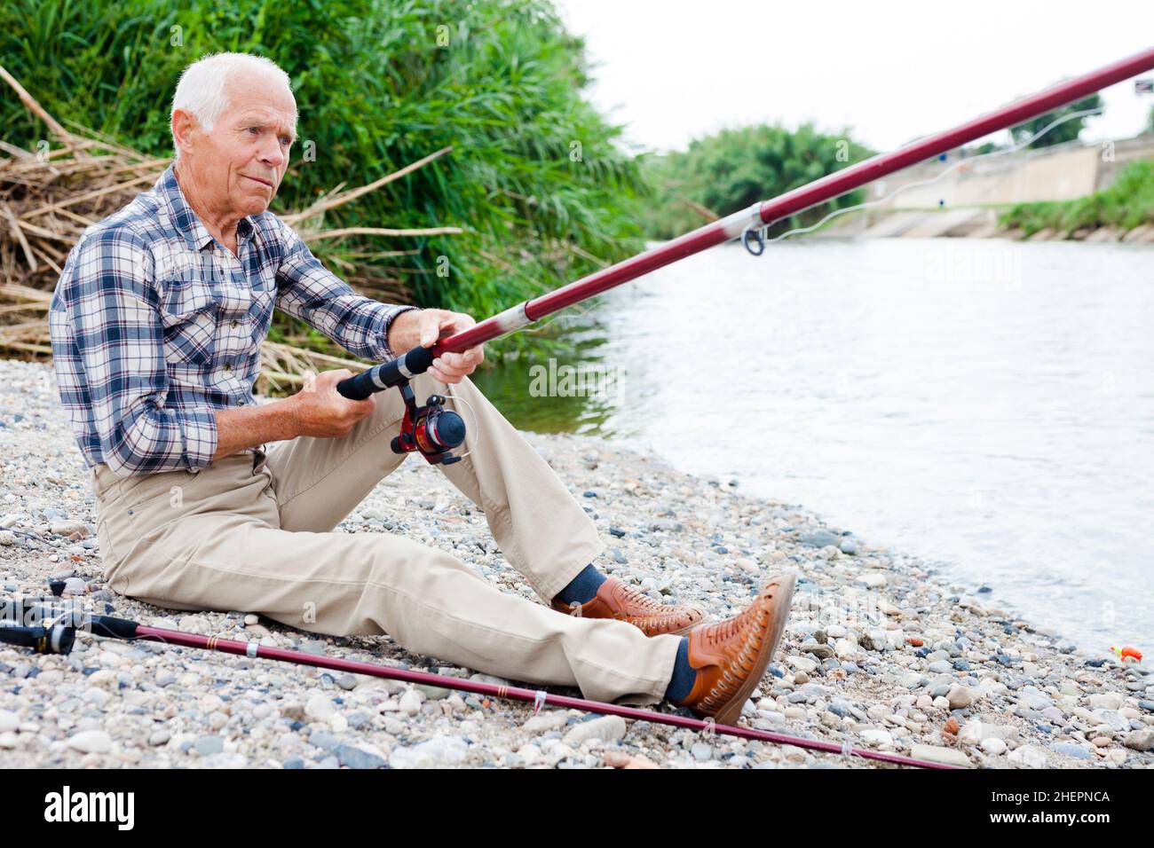 Aged man fishing at lakeside Stock Photo - Alamy