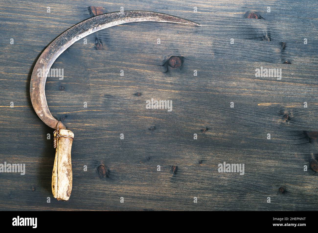 An old sickle on a wooden rustic dark background. Top view Stock Photo ...