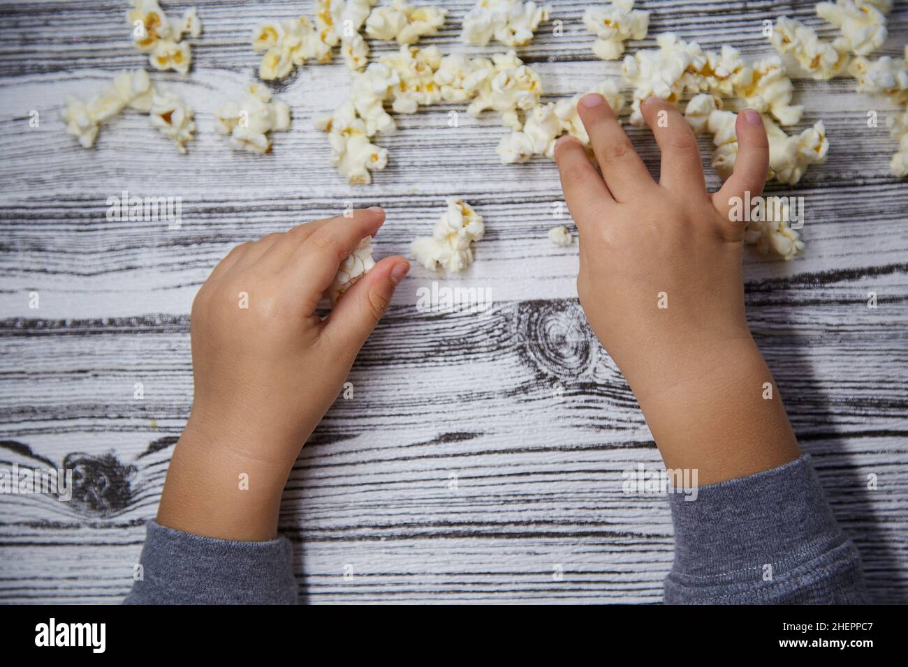 Toddler hands try a popcorn. Kid's curiosity. National Popcorn Day ...