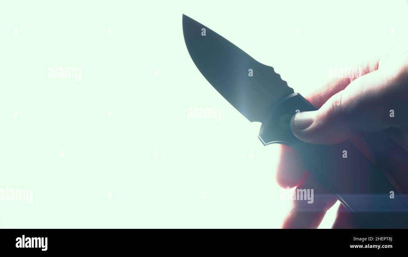 Sharp knife in male hand with copy space. EDC automatic folding pocket ...