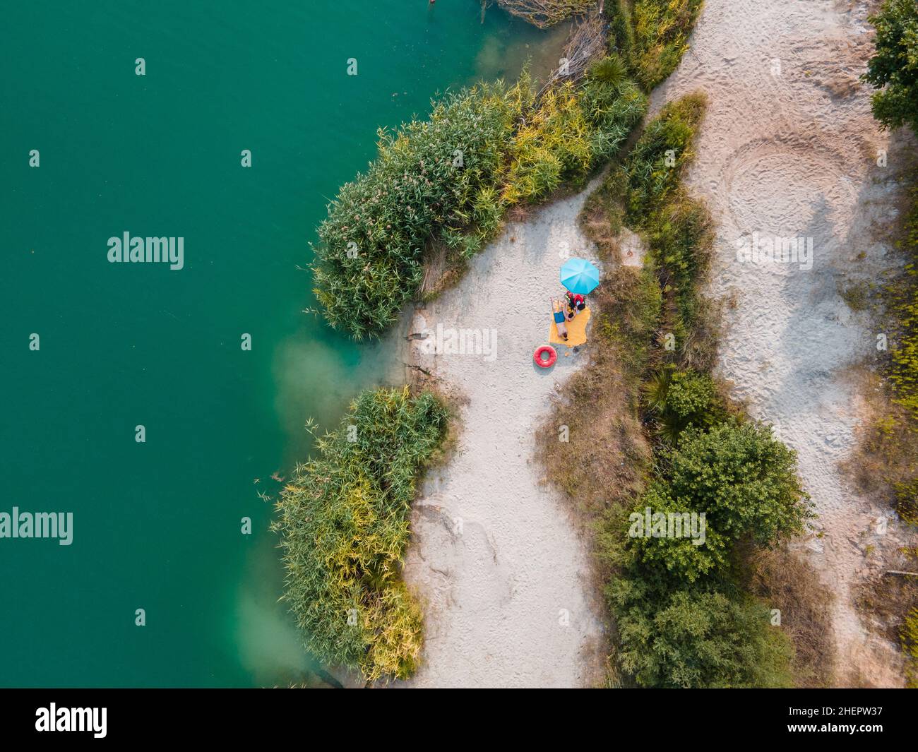 couple laying on blanket sunbathing at sandy beach blue azure water ...