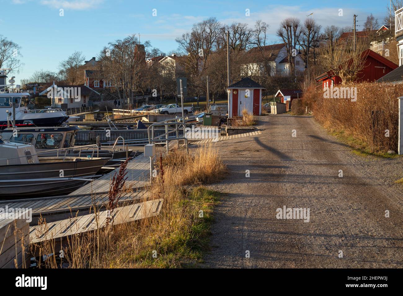 Winter day in a small harbour in Sweden. Rural road. Small boats ...
