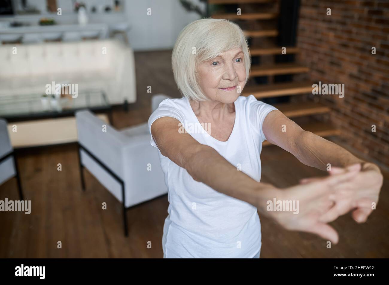 Woman in a white tshirt stretching her arms forward Stock Photo - Alamy