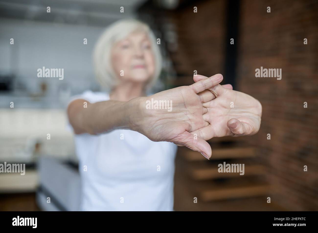 Woman in a white tshirt stretching her arms forward Stock Photo - Alamy